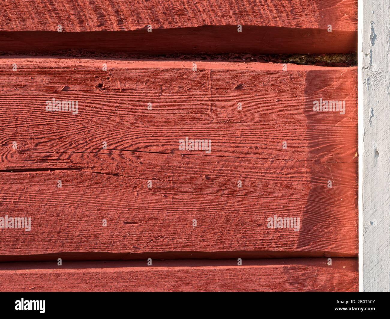 Log house wall painted red Stock Photo - Alamy