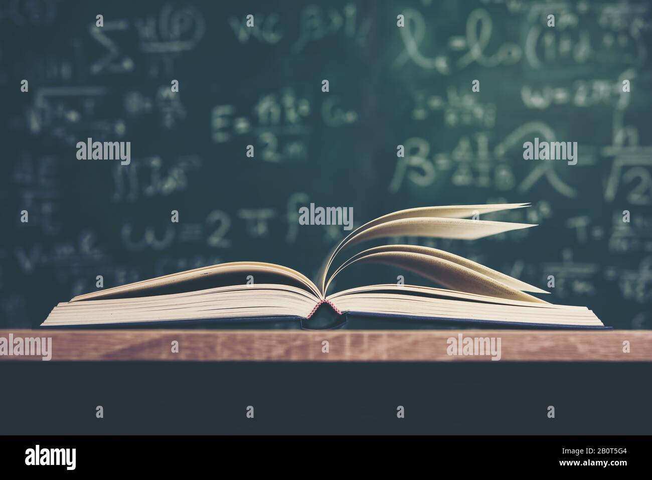 Open book with green board background Stock Photo - Alamy