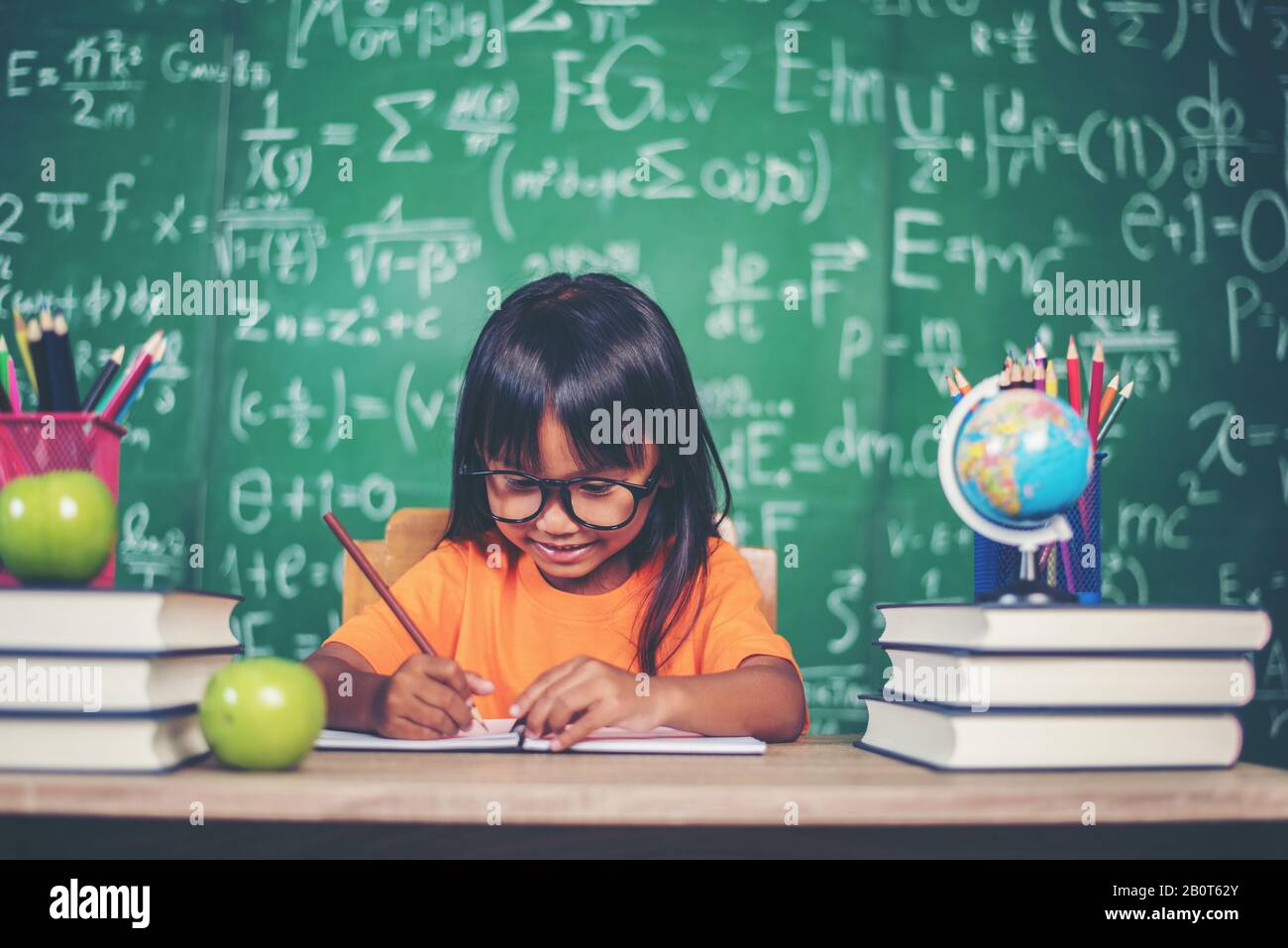 girl with crayon drawing at lesson in the classroom Stock Photo - Alamy