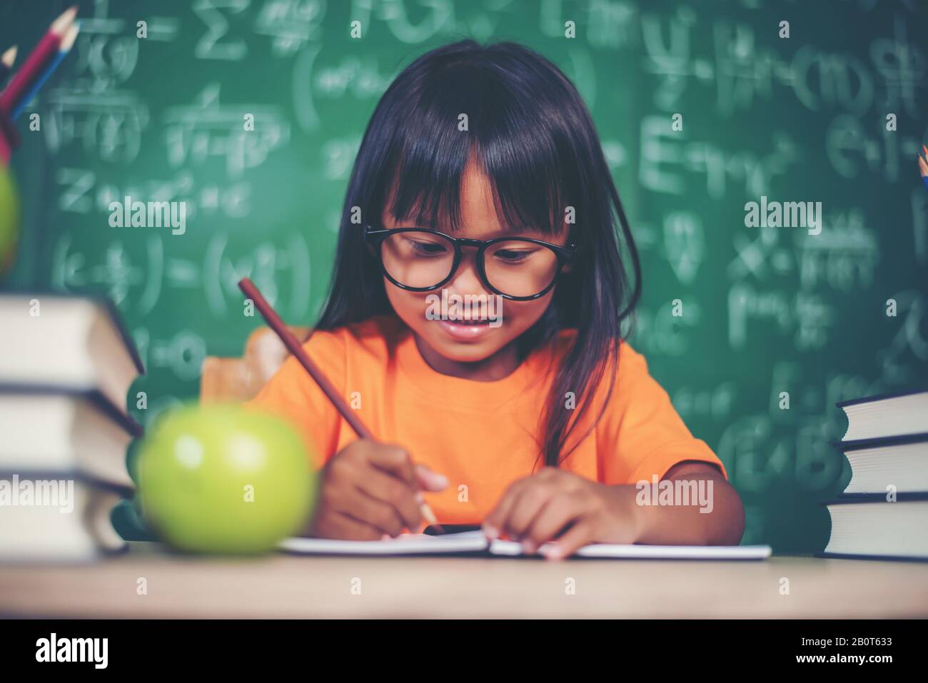 girl with crayon drawing at lesson in the classroom Stock Photo - Alamy