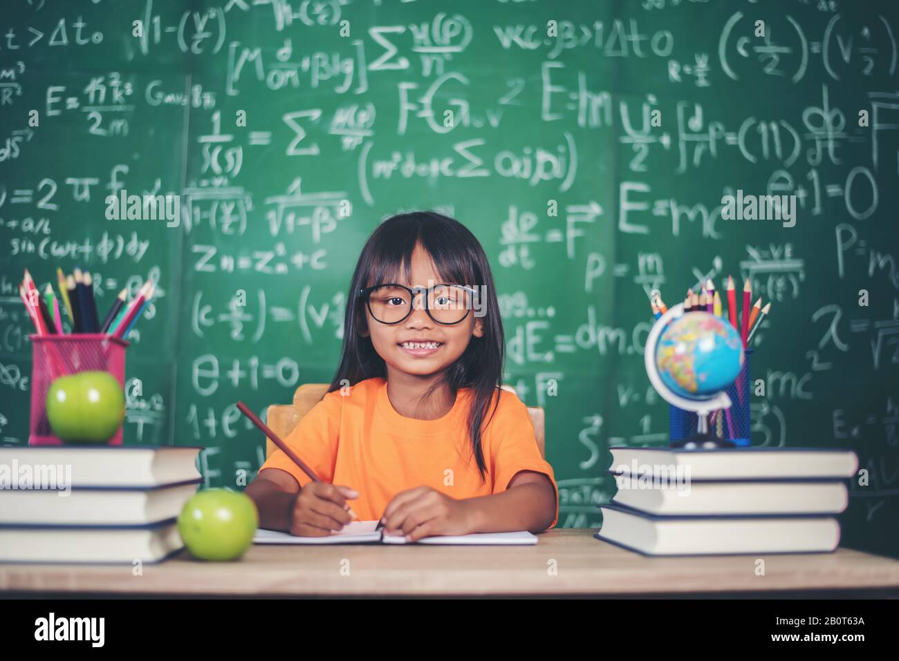 girl with crayon drawing at lesson in the classroom Stock Photo - Alamy