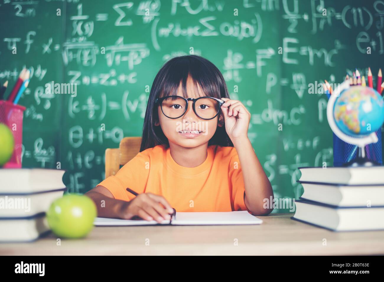 girl with crayon drawing at lesson in the classroom Stock Photo - Alamy