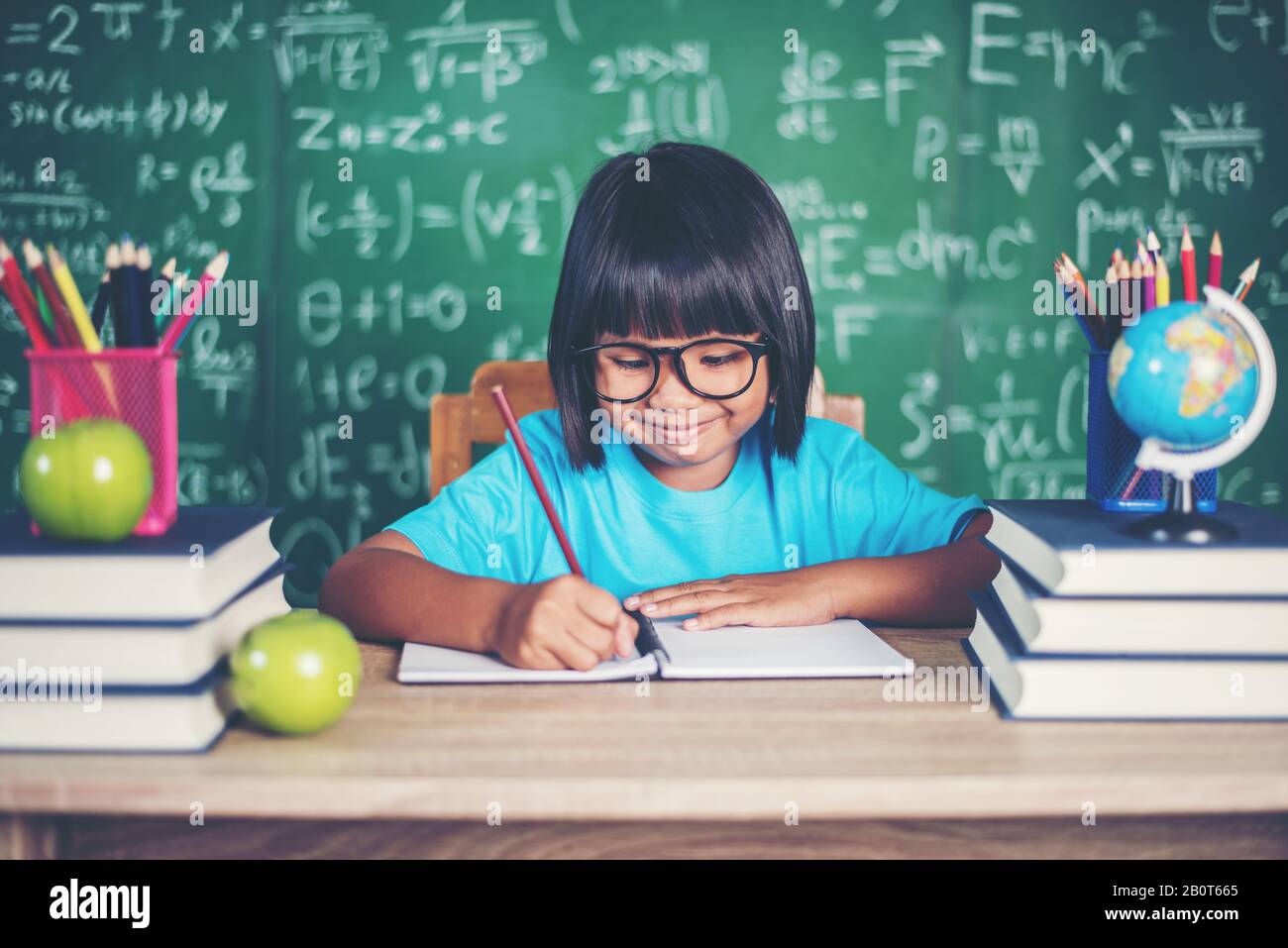 girl with crayon drawing at lesson in the classroom Stock Photo - Alamy