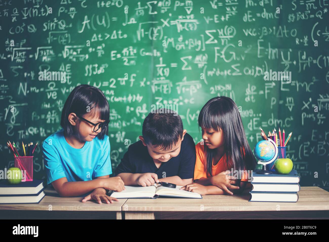 pupils reading a book in the classroom Stock Photo - Alamy