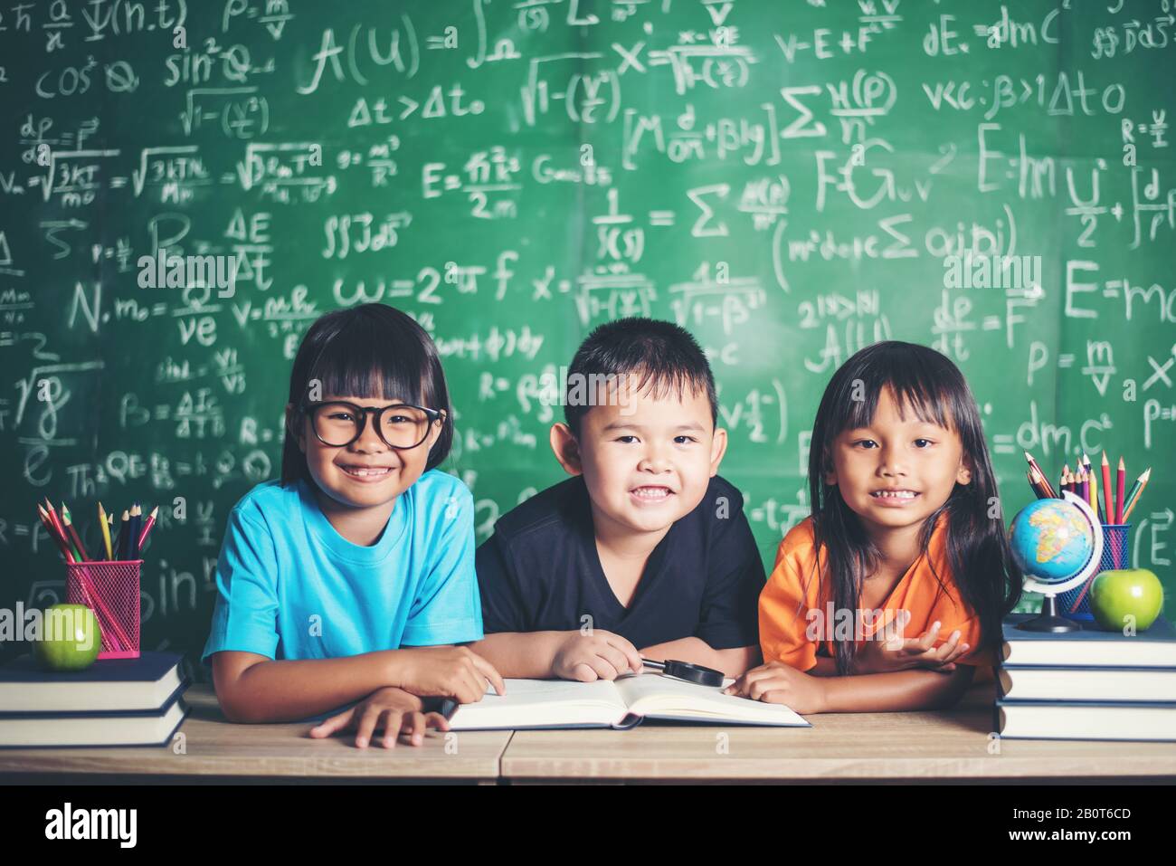 pupils reading a book in the classroom Stock Photo - Alamy