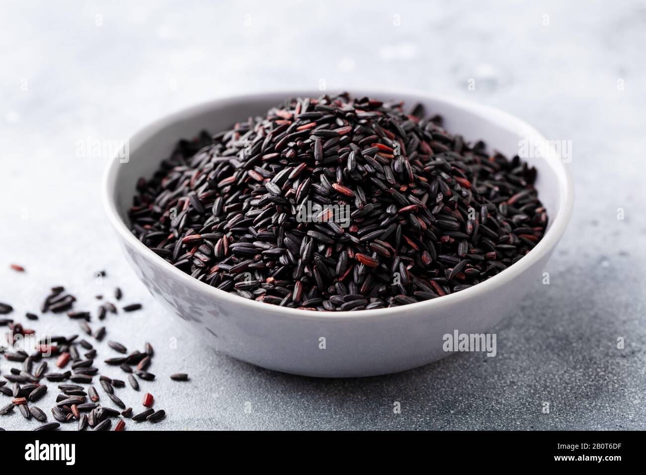 Black wild rice in a bowl. Grey stone background. Close up Stock Photo ...