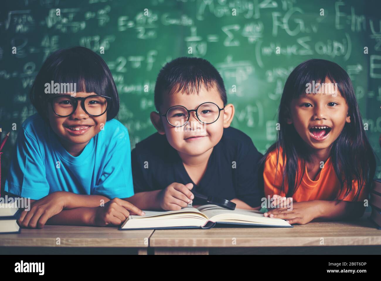 pupils reading a book in the classroom Stock Photo - Alamy