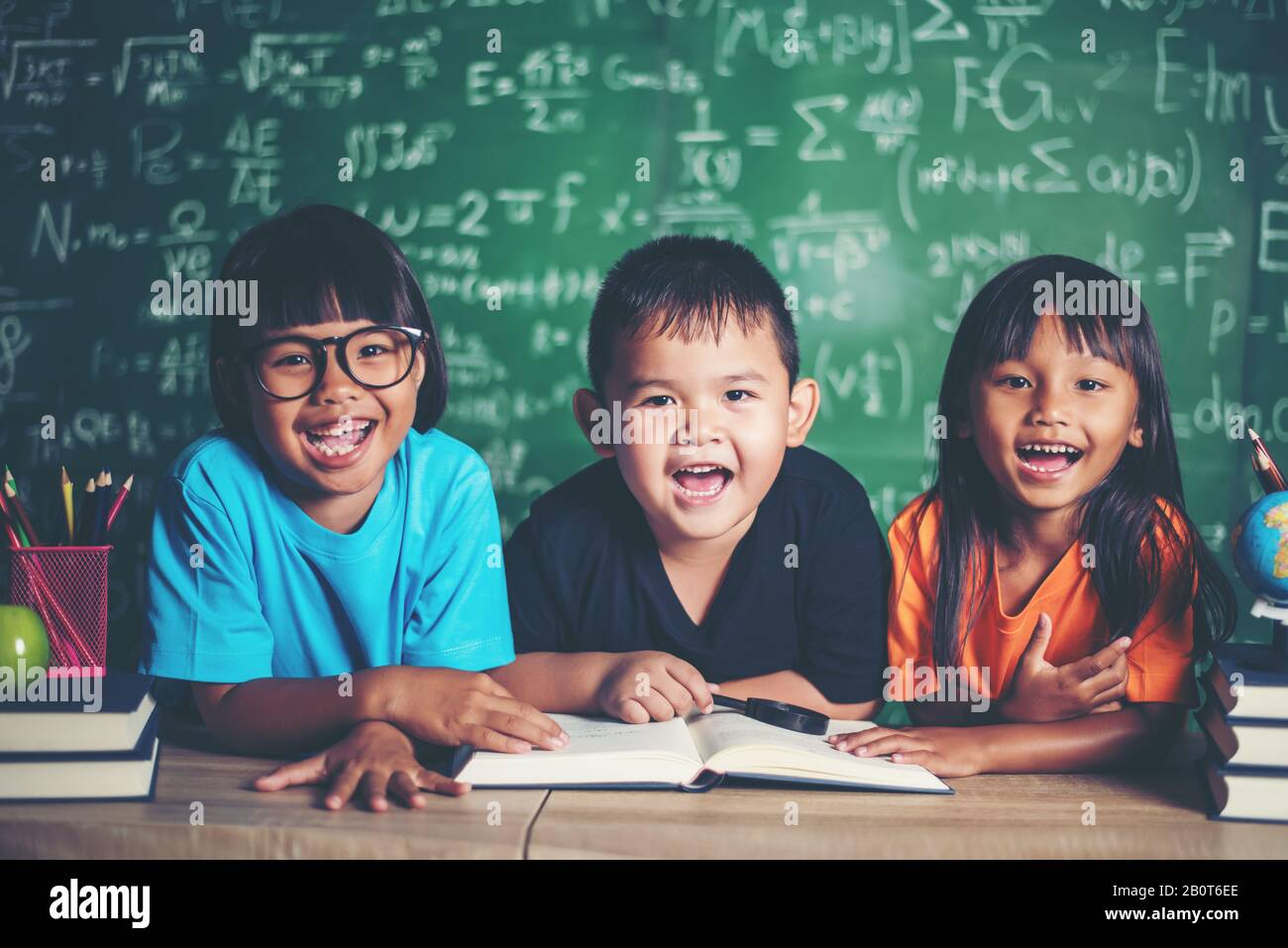 pupils reading a book in the classroom Stock Photo - Alamy