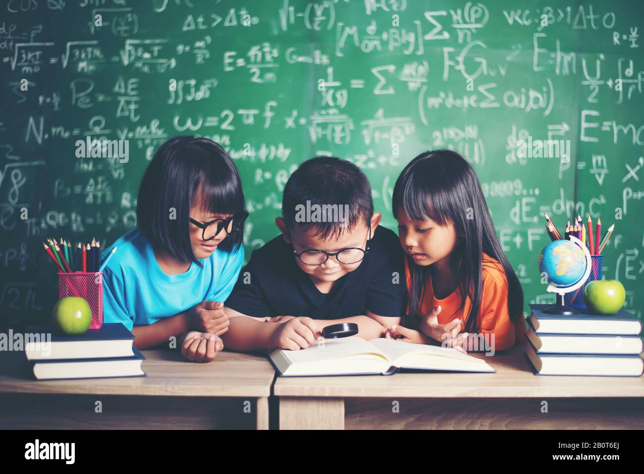 pupils reading a book in the classroom Stock Photo - Alamy