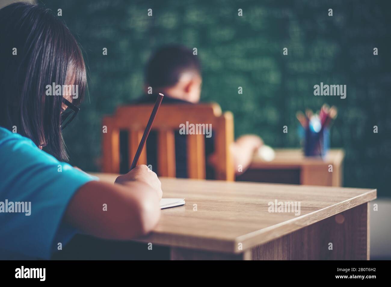 girl with crayon drawing at lesson in the classroom Stock Photo - Alamy