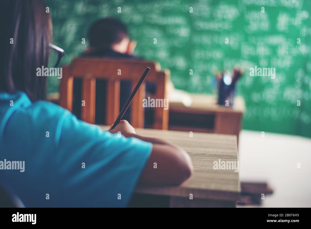 girl with crayon drawing at lesson in the classroom Stock Photo - Alamy