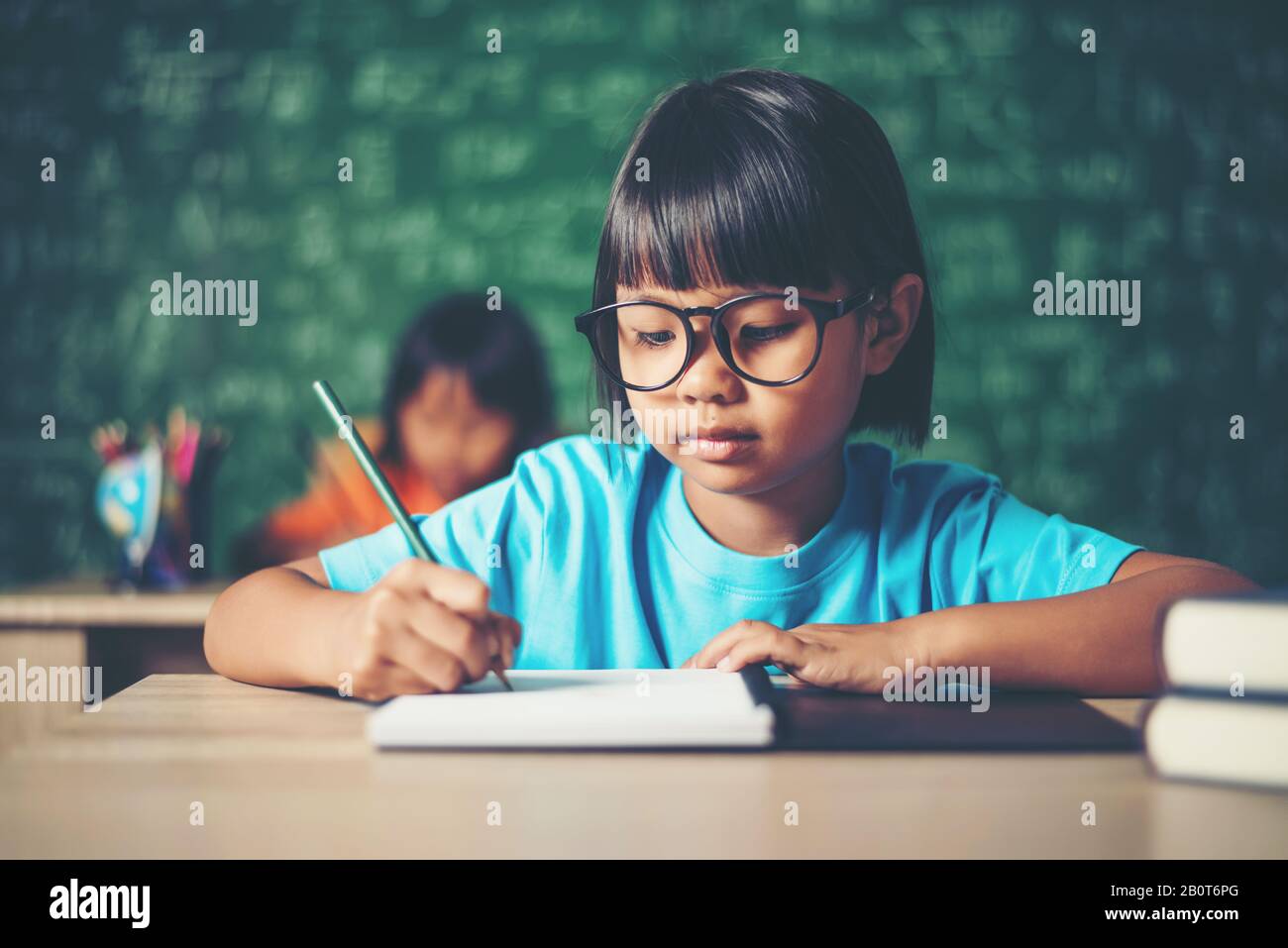 girl with crayon drawing at lesson in the classroom Stock Photo - Alamy