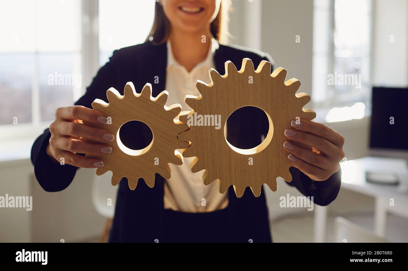 Faceless Businesswoman holding wooden gears in his hands in the office ...