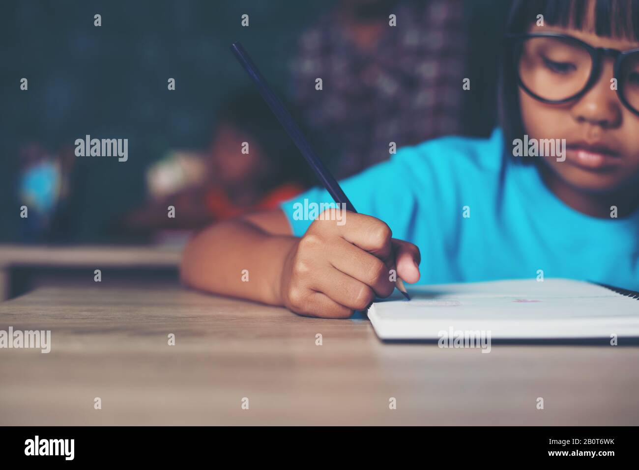 girl with crayon drawing at lesson in the classroom Stock Photo - Alamy