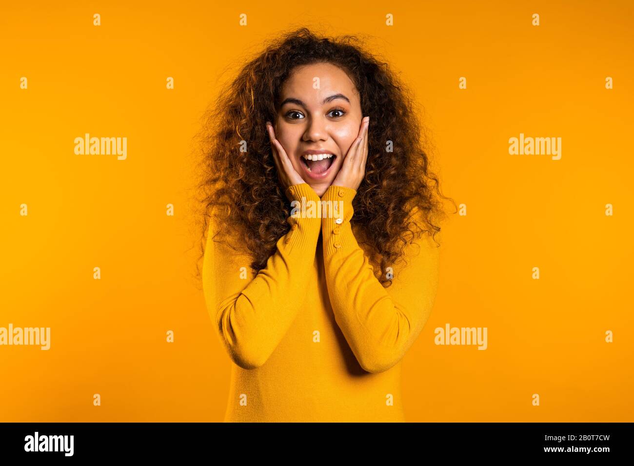 Girl with curly hair very glad and happy, she shows yes gesture of ...