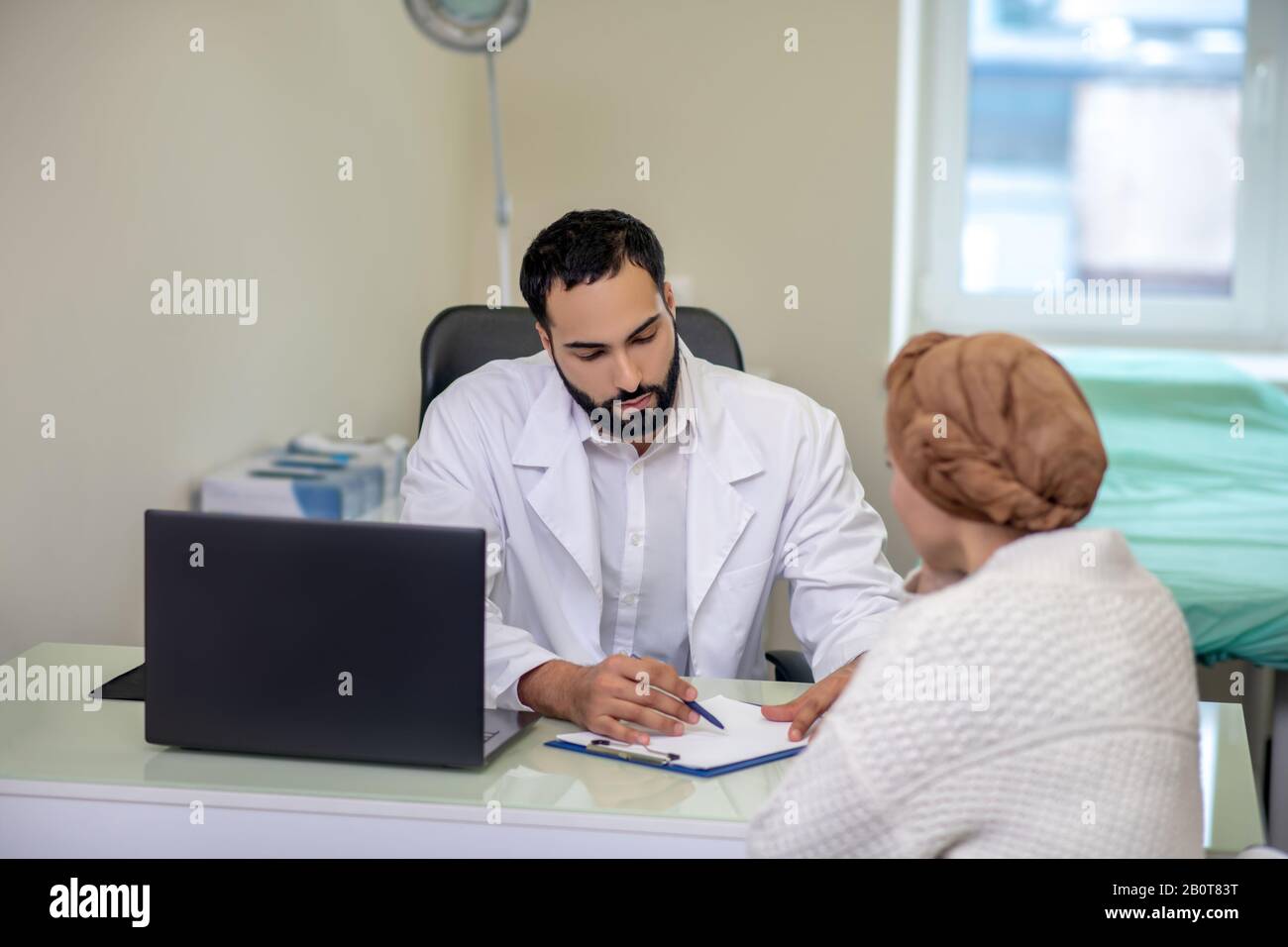 Male doctor showing investigation results to the patient Stock Photo ...