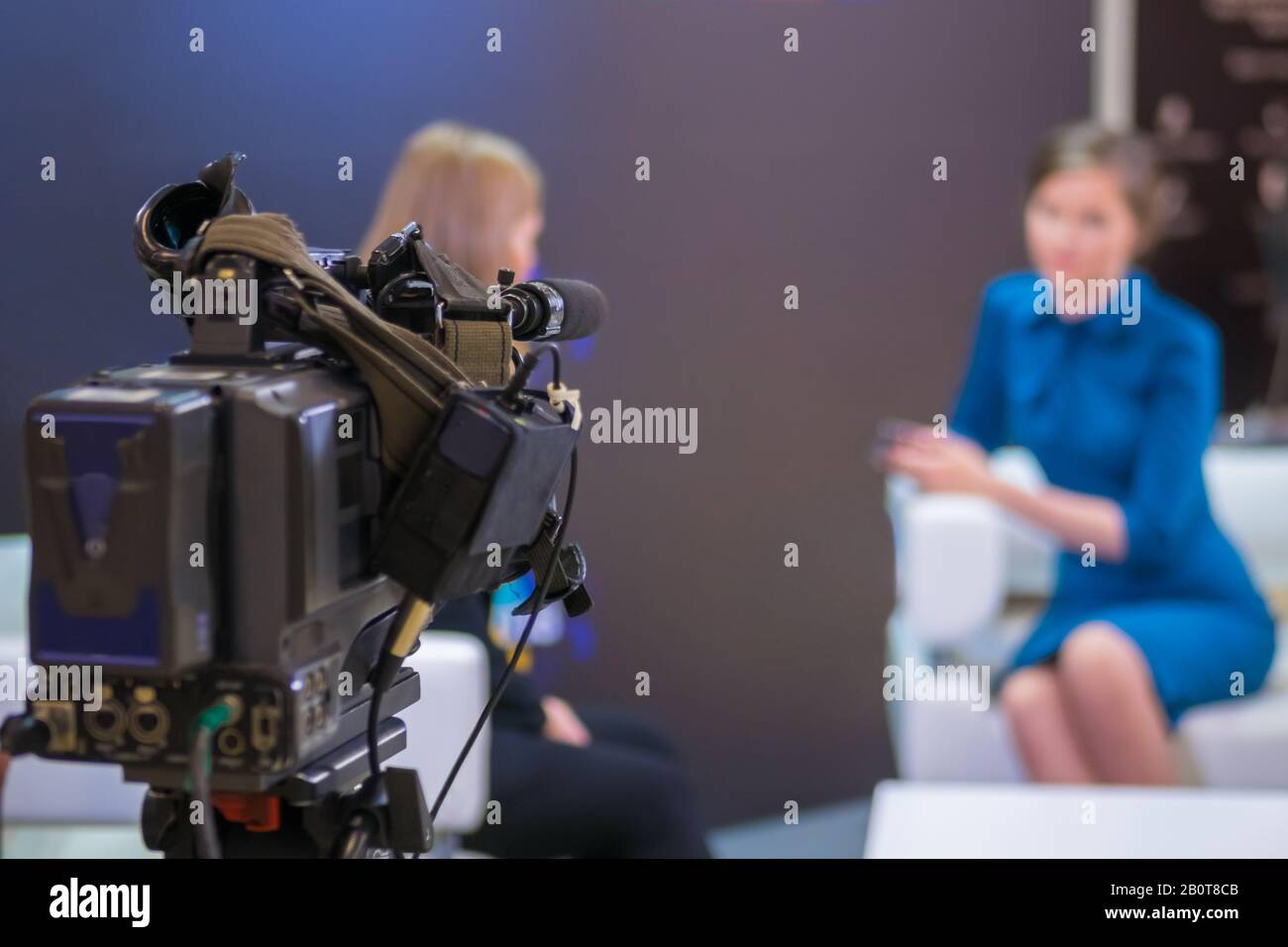 Television video camera recording interview in broadcast news studio ...