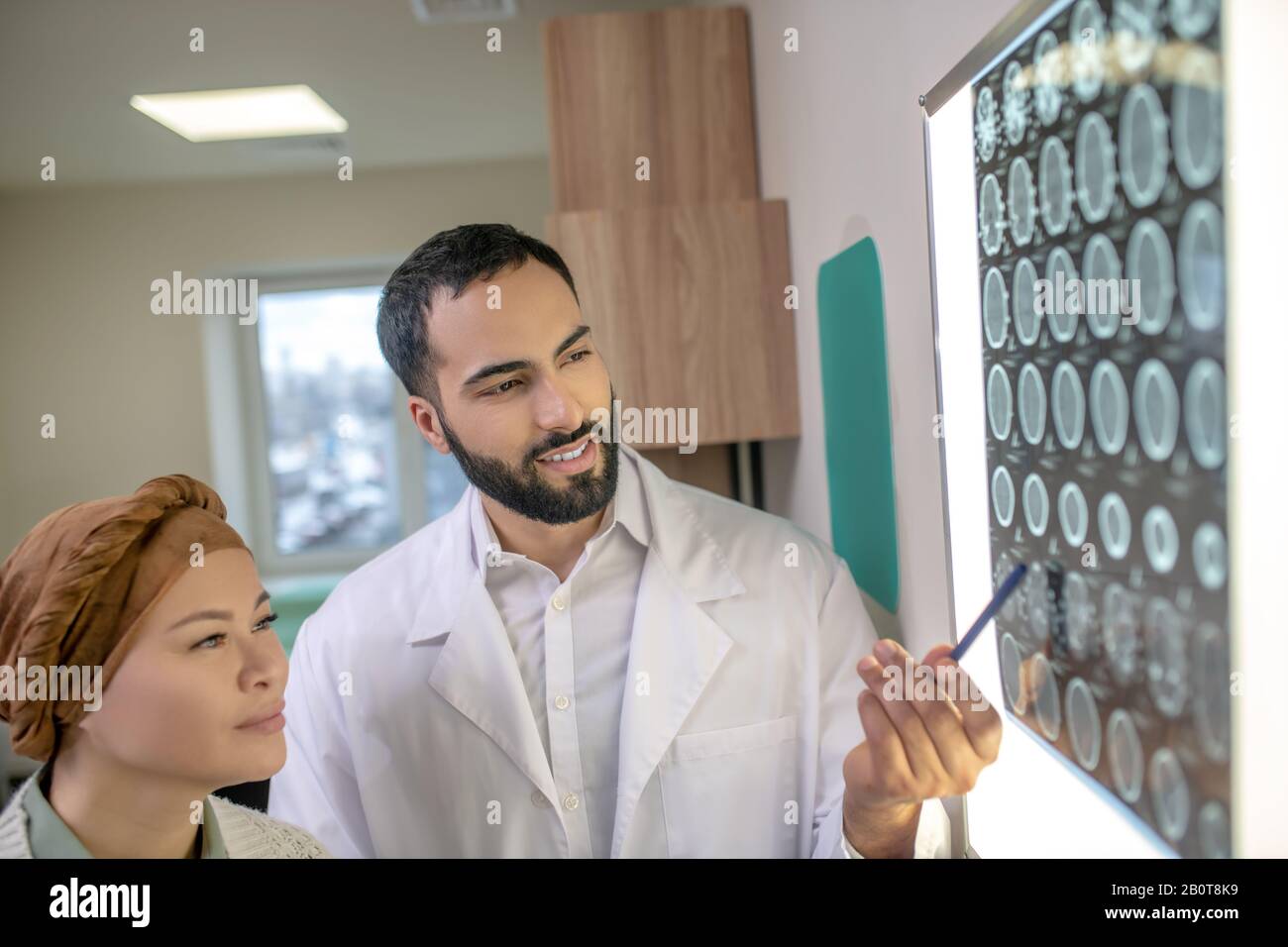 Bearded young doctor explaining MRI results to the patient Stock Photo ...