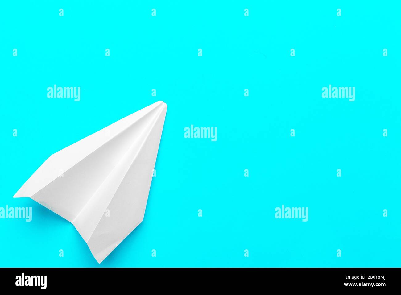 Flat lay of white paper plane and blank paper on pastel blue color ...