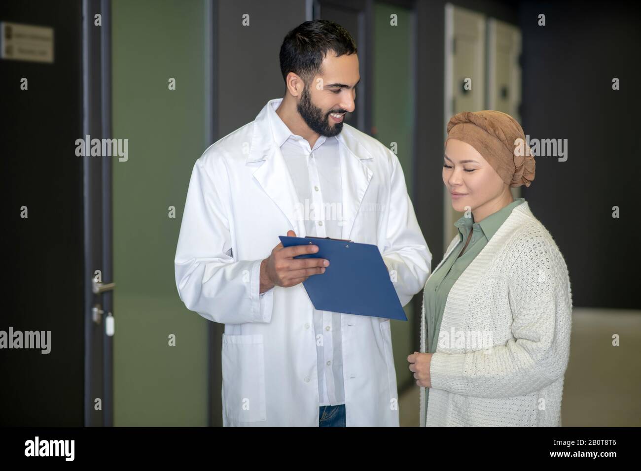 Tall male young doctor having conversatio with a female patient Stock ...