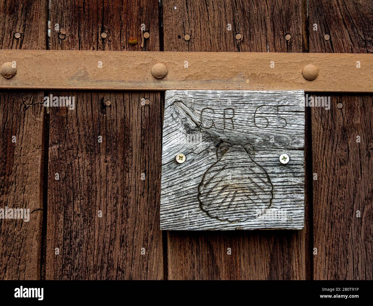 Scallop shell on a wooden door in Conques, Aveyron department ...