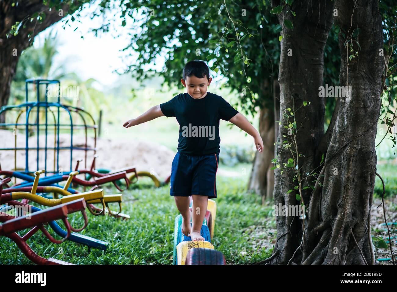 Kids running on tires in the playground Stock Photo - Alamy