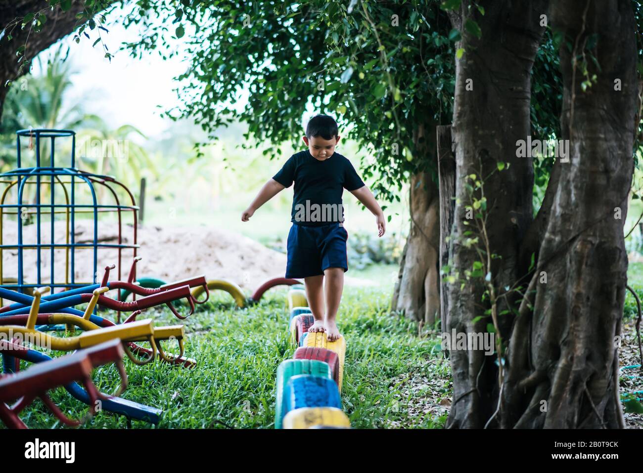 Kids running on tires in the playground Stock Photo - Alamy