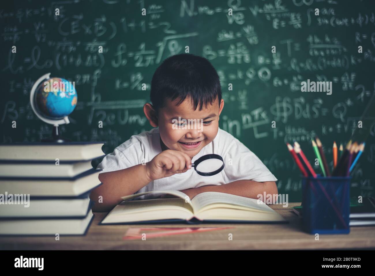 kid observing or studying educational globe model in the classroom ...