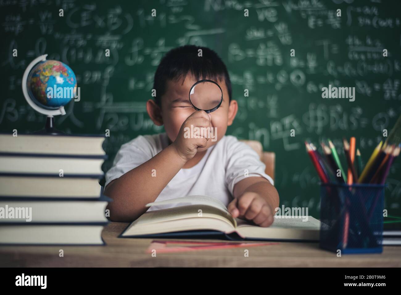 kid observing or studying educational globe model in the classroom ...