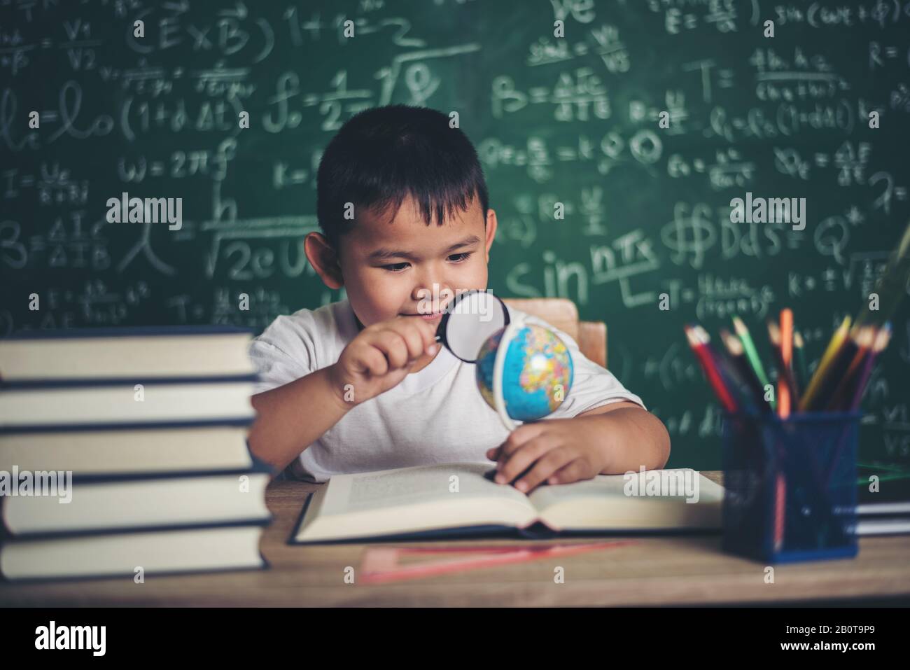 kid observing or studying educational globe model in the classroom ...