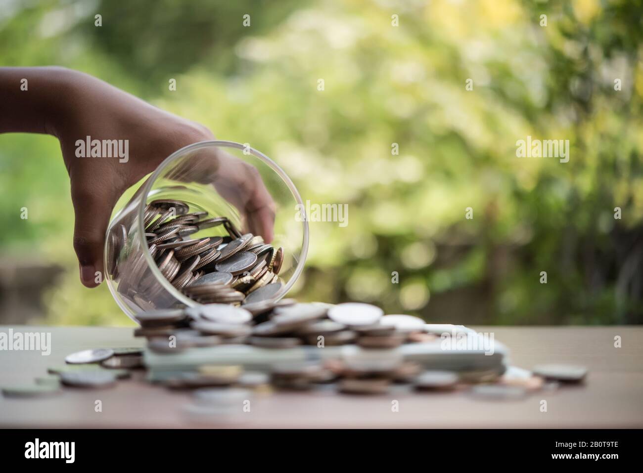 Hand putting coins in jar with money stack step growing growth saving ...