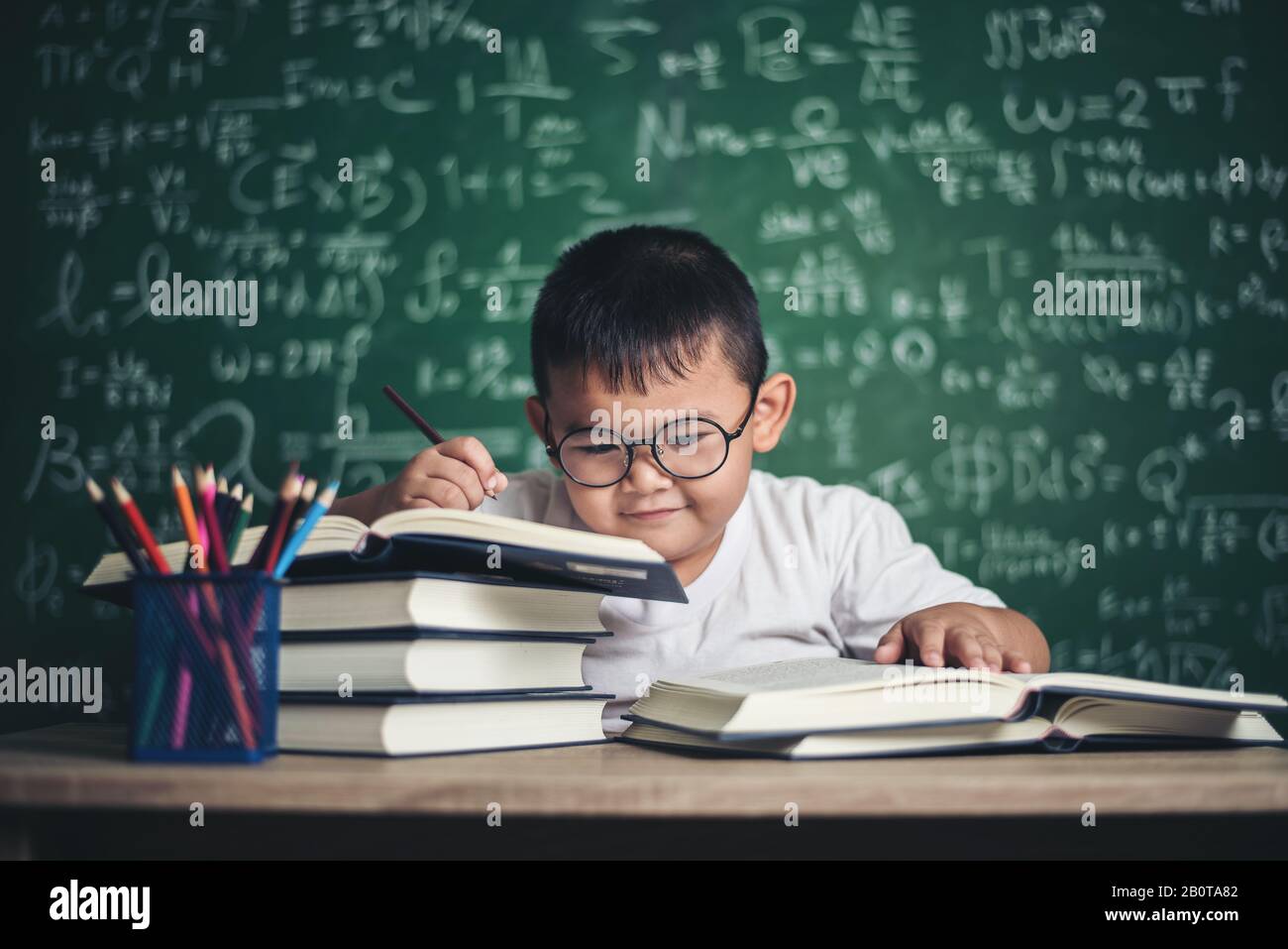 boy write a book in the classroom Stock Photo - Alamy