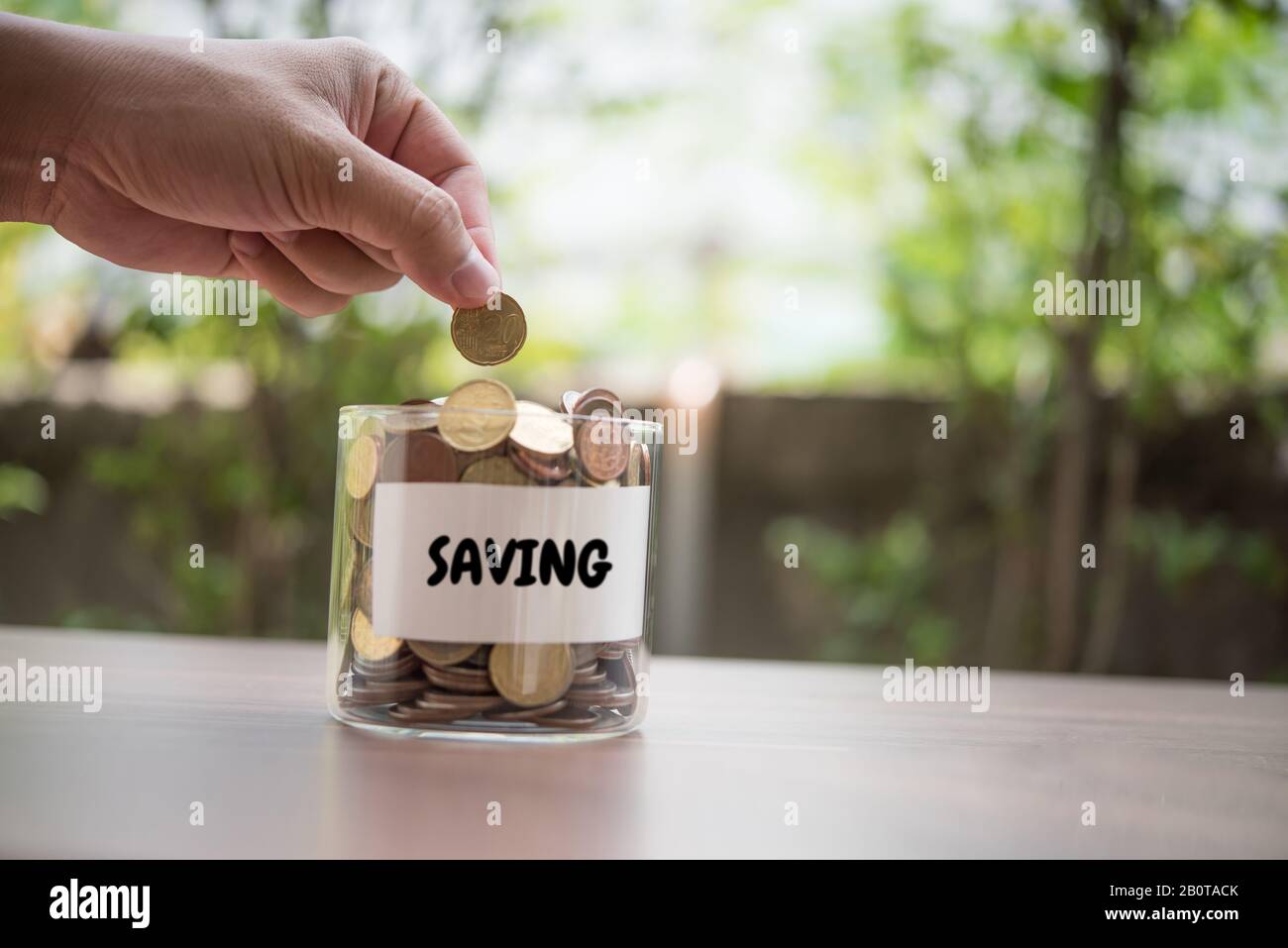 Hand putting coins in jar with money stack step growing growth saving ...