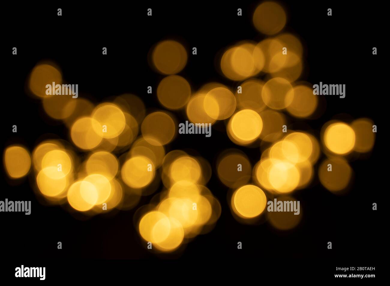 yellow bokeh dots on dark black background Stock Photo - Alamy