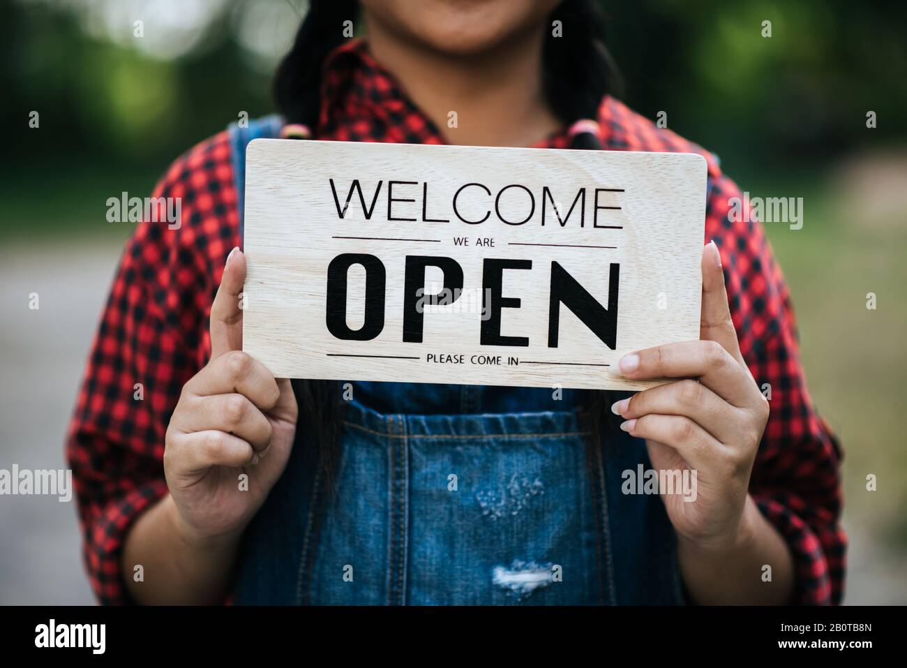 Girl holding an open sign Stock Photo - Alamy