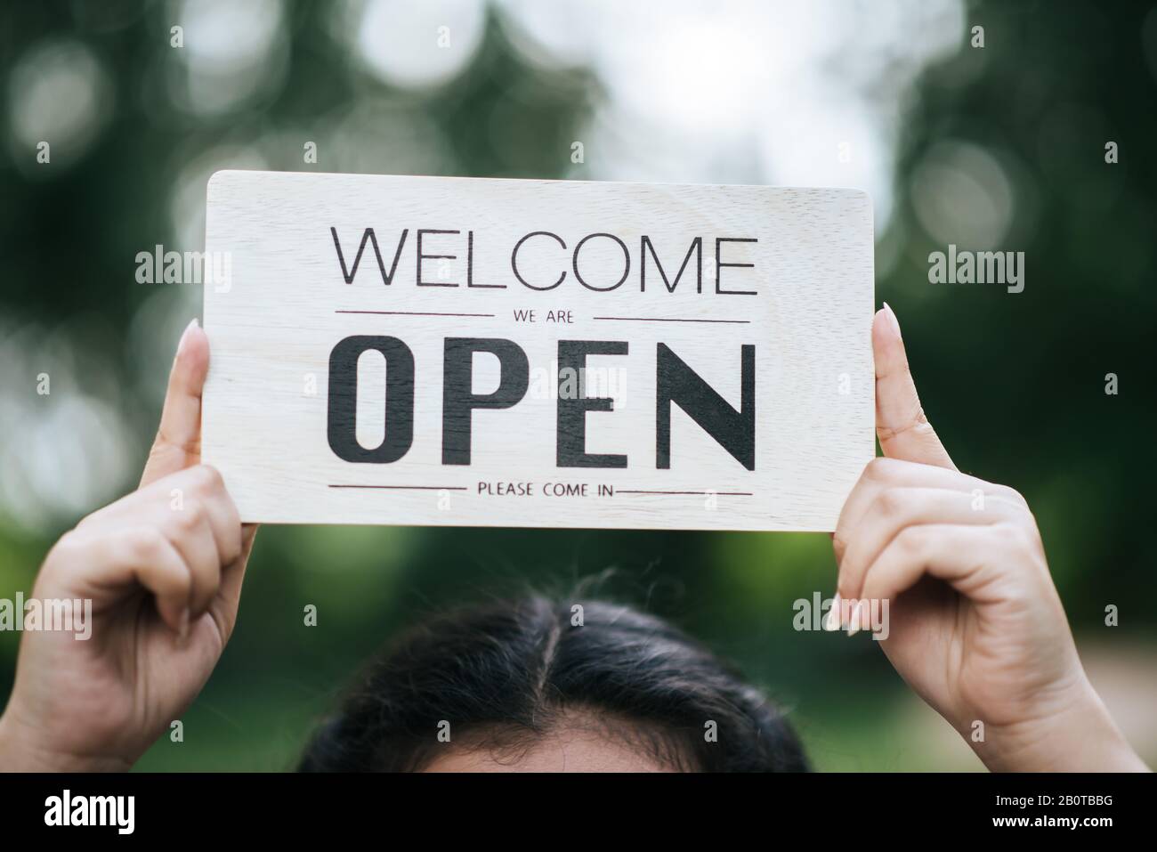 Girl holding an open sign Stock Photo - Alamy
