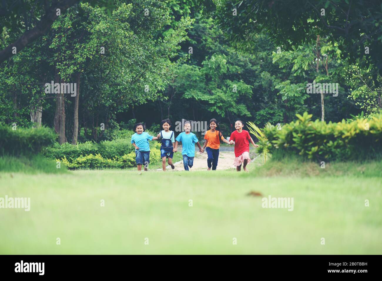 Group Of Young Children Running and playing in the park Stock Photo - Alamy