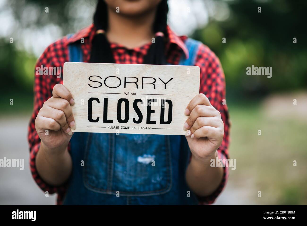 Girl holding an closed sign Stock Photo - Alamy