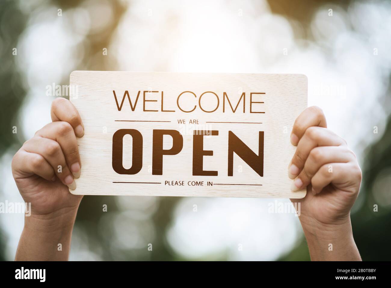 Girl holding an open sign Stock Photo - Alamy