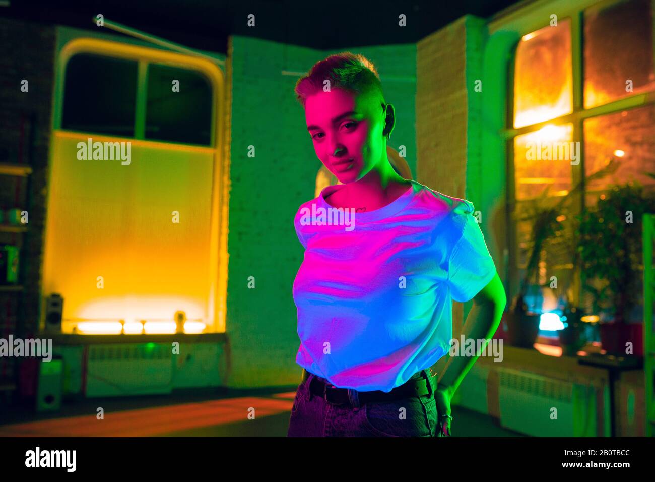 Cinematic portrait of stylish woman in neon lighted interior. Toned ...