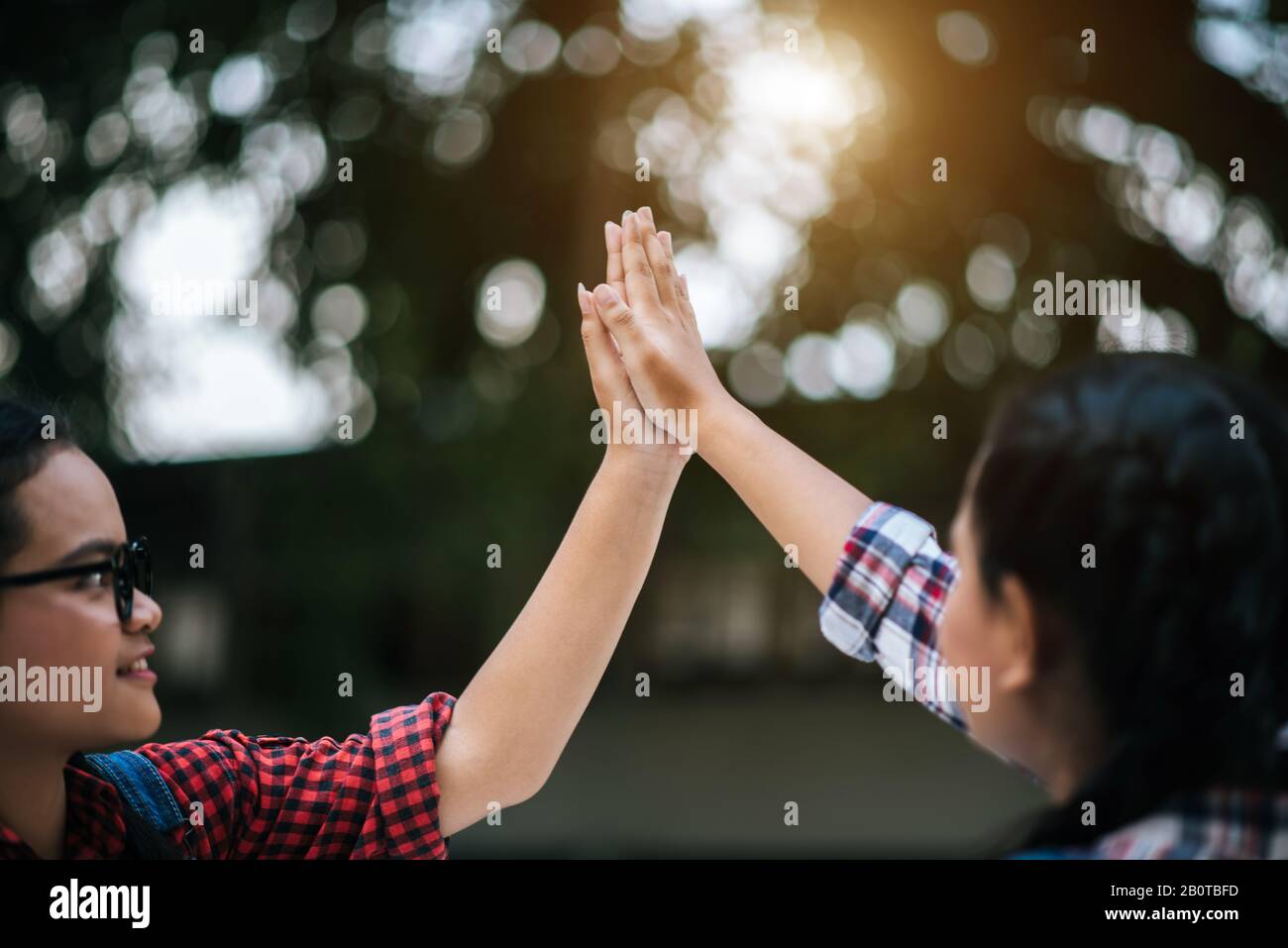 Two girls college student giving high five celebrating Stock Photo - Alamy