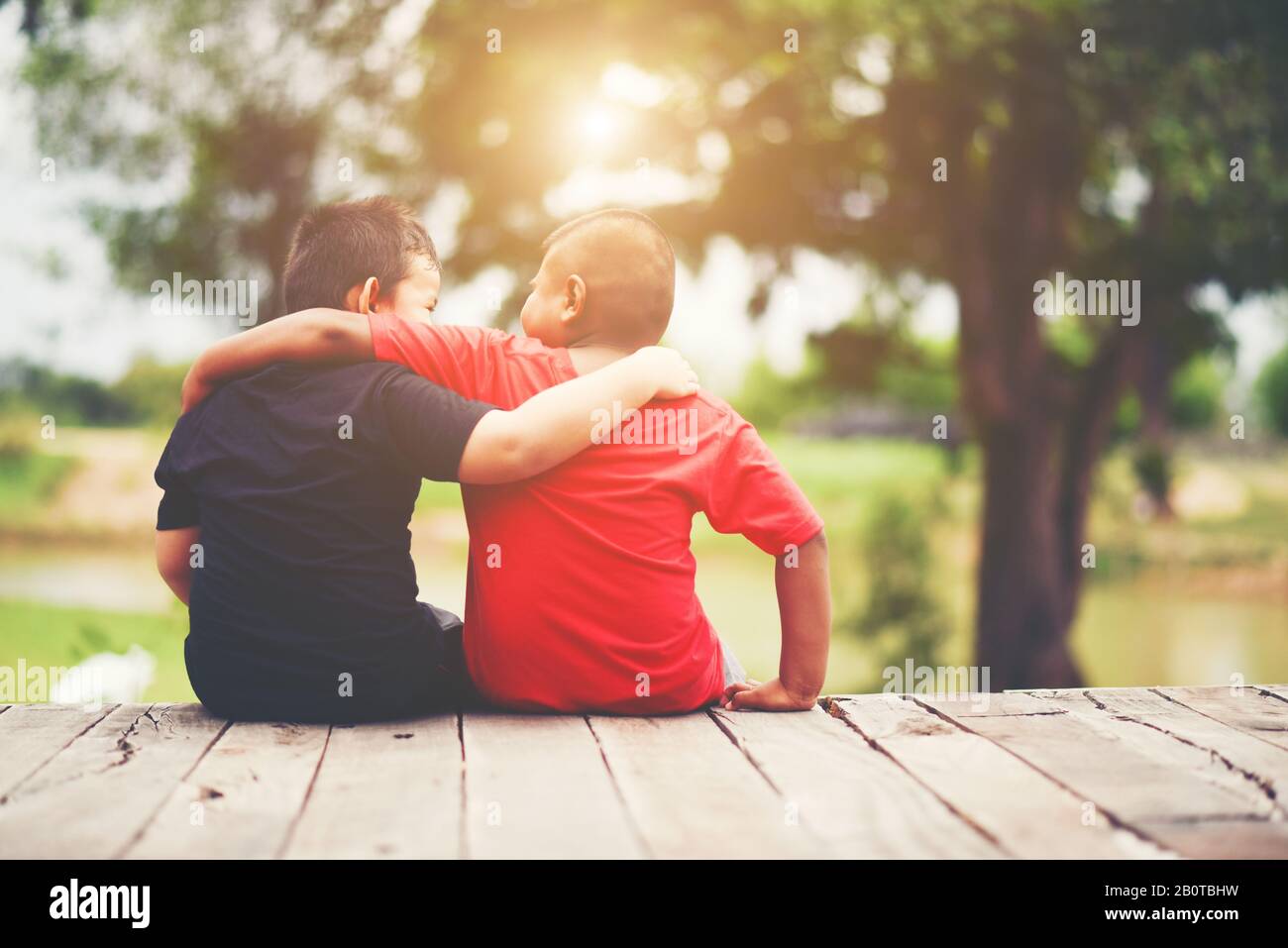 Group of kids friends arm around sitting together Stock Photo - Alamy