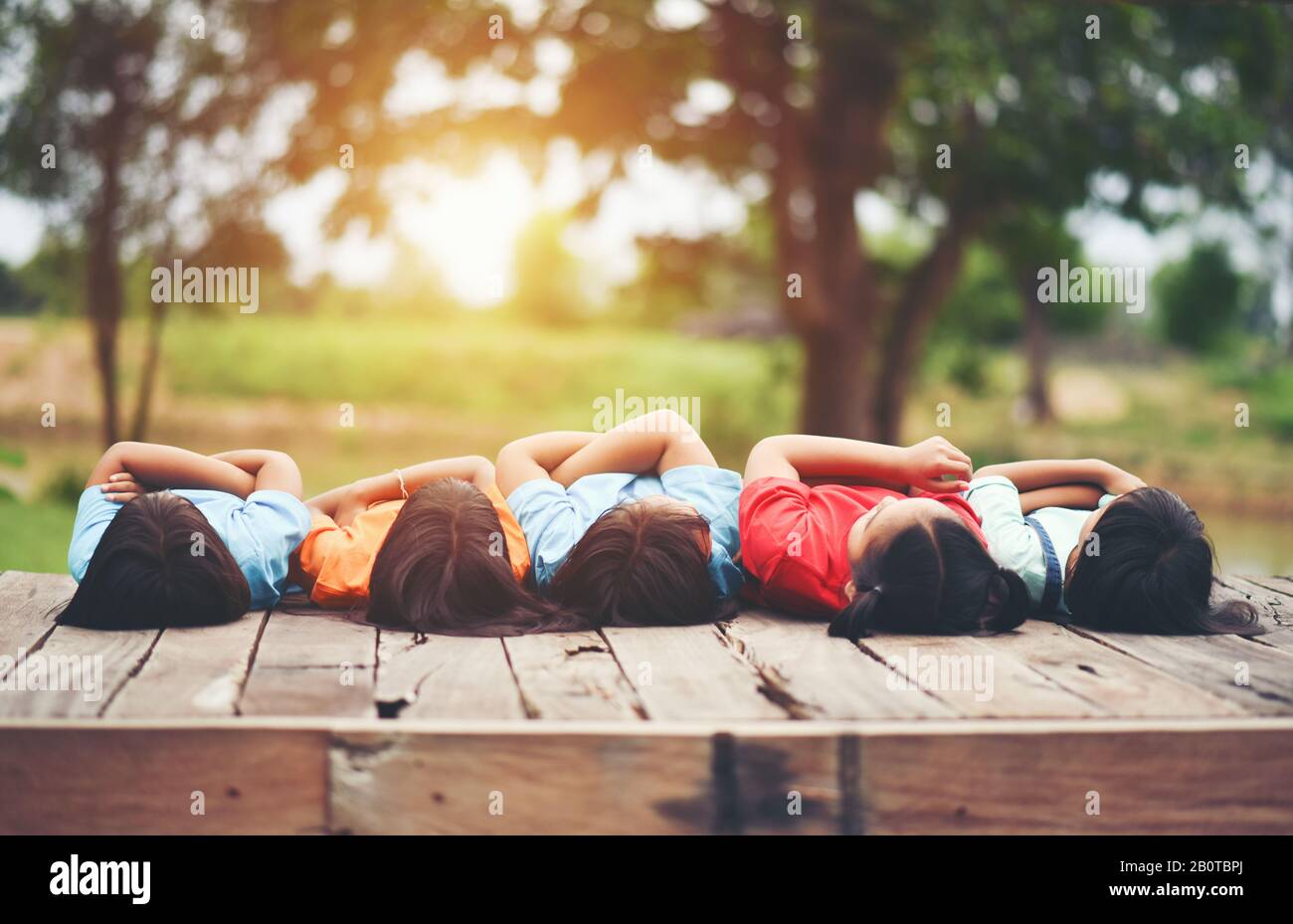 Group of kids friends arm around sitting together Stock Photo - Alamy
