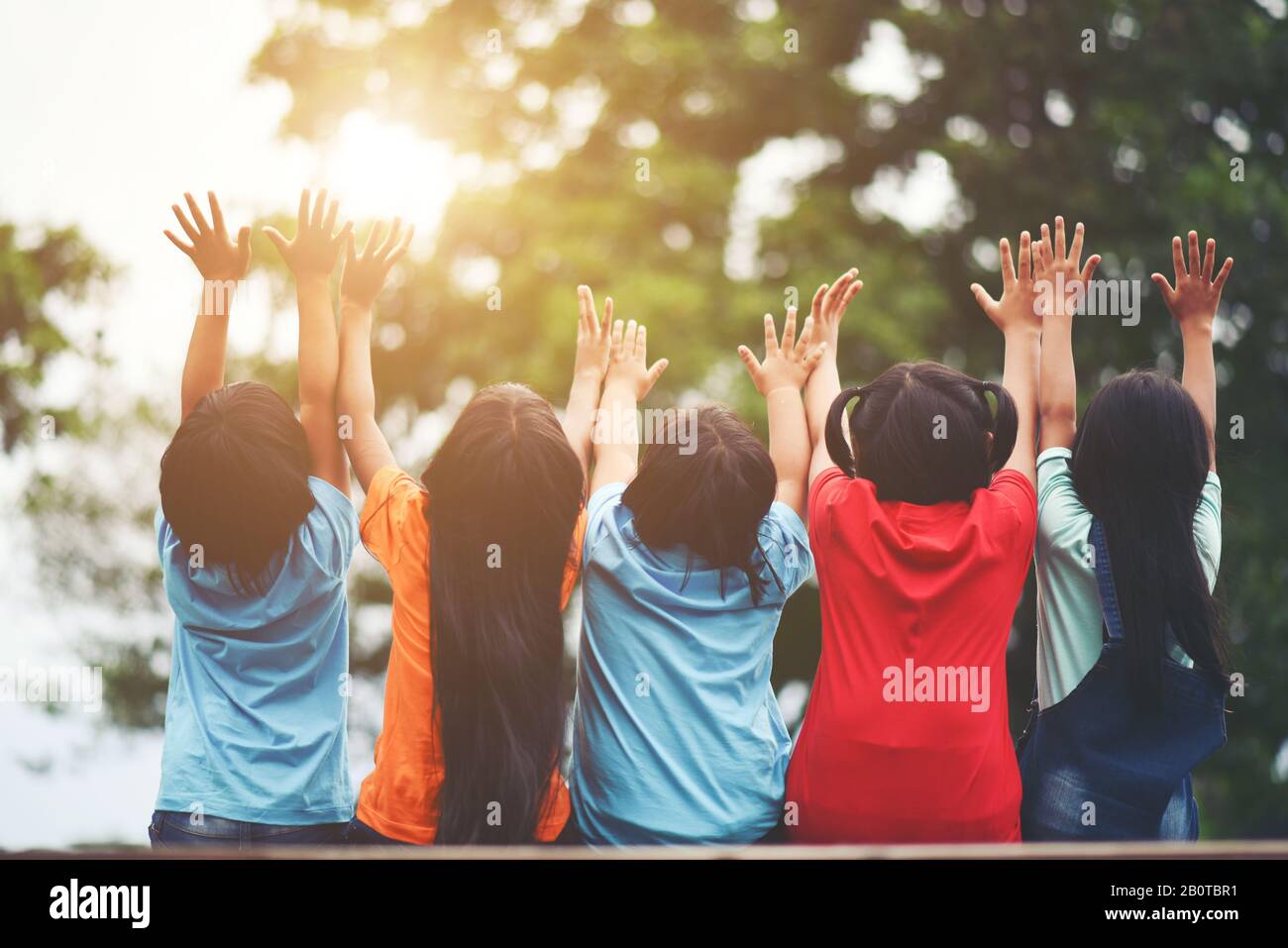 Group of kids friends arm around sitting together Stock Photo - Alamy