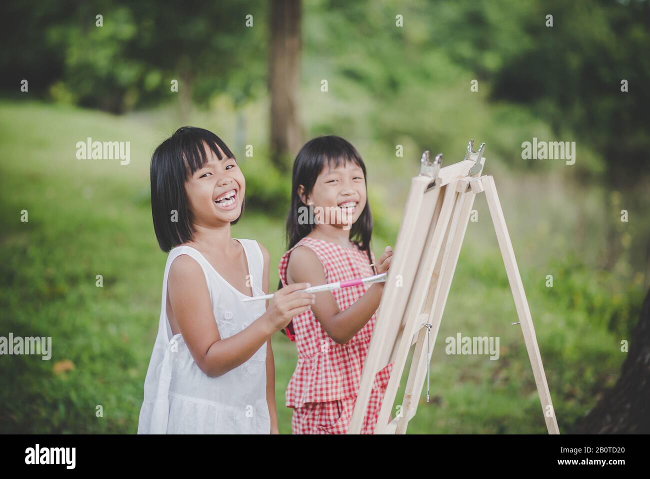 Two little girl painter art drawing in the park Stock Photo - Alamy