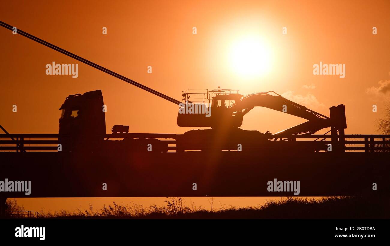 low loader carrying caterpillar digger crossing the river ouse over ...