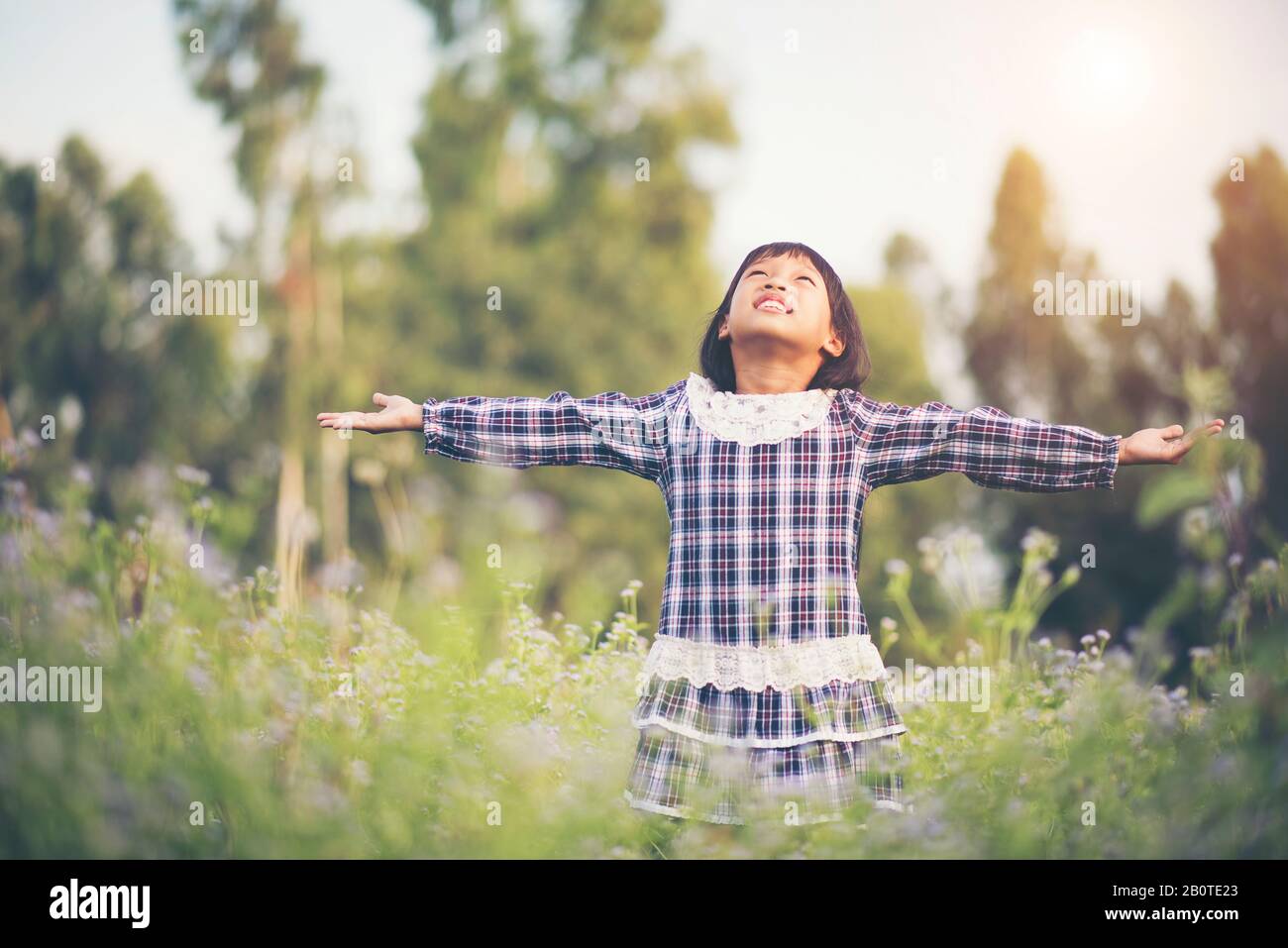 Little girl raising hand refresh in the air Stock Photo - Alamy