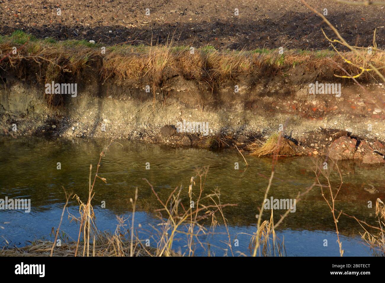 soil degradation or soil movement on a small creek close-up, little ...
