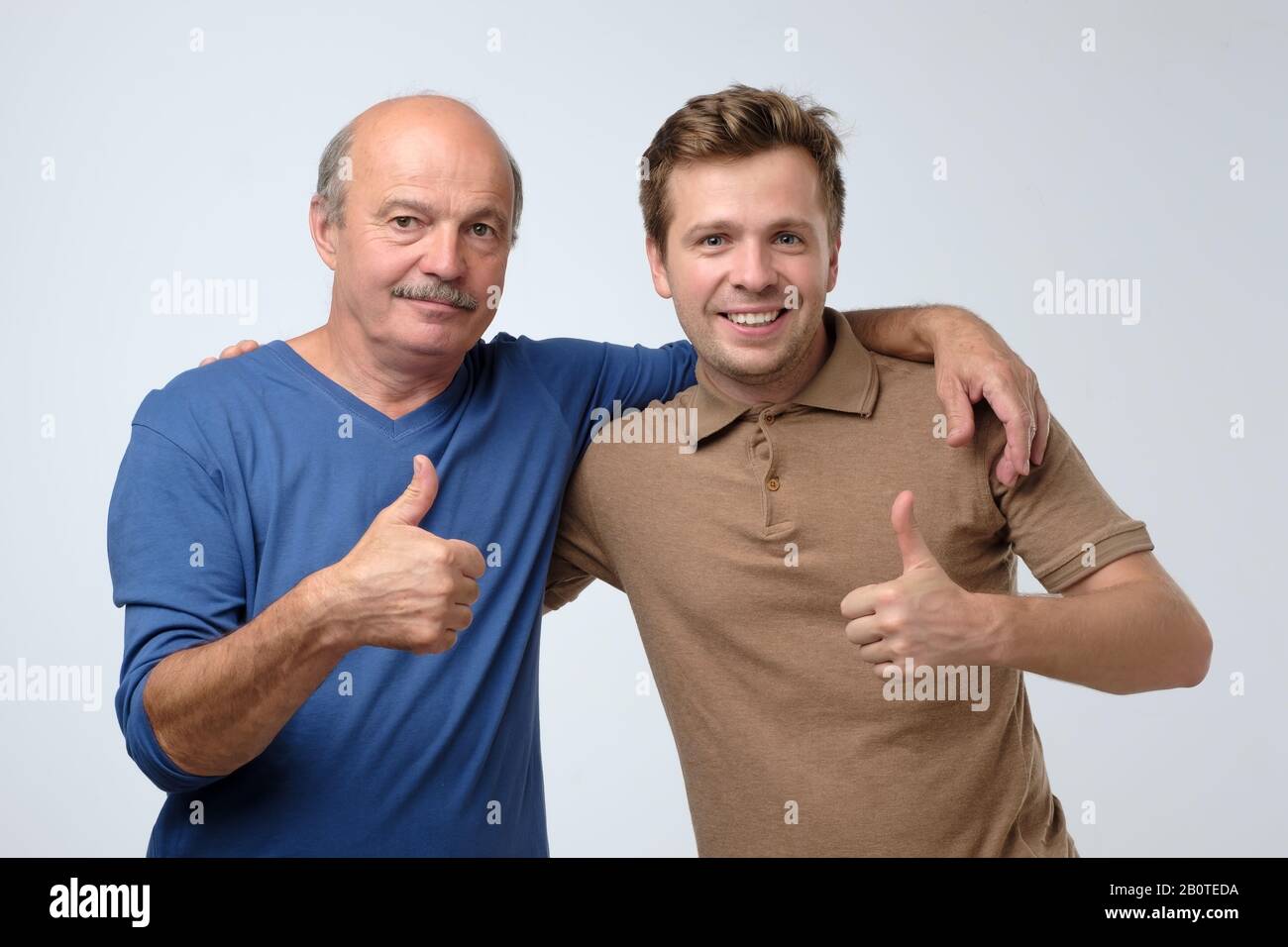 Two happy men father and son with thumbs up gesture, isolated on white ...