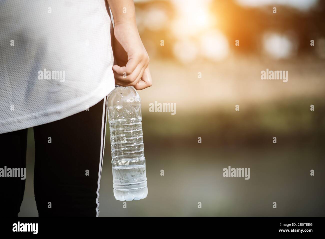 Young fitness woman hand holding water bottle after running exercise ...
